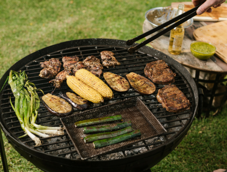 Cooking steak and chicken on a kadai fire pit - Sticks and Stones Outdoor